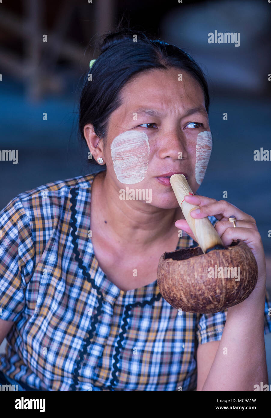Woman smoking a cheroot cigar in market in bagan, Myanmar Stock Photo ...