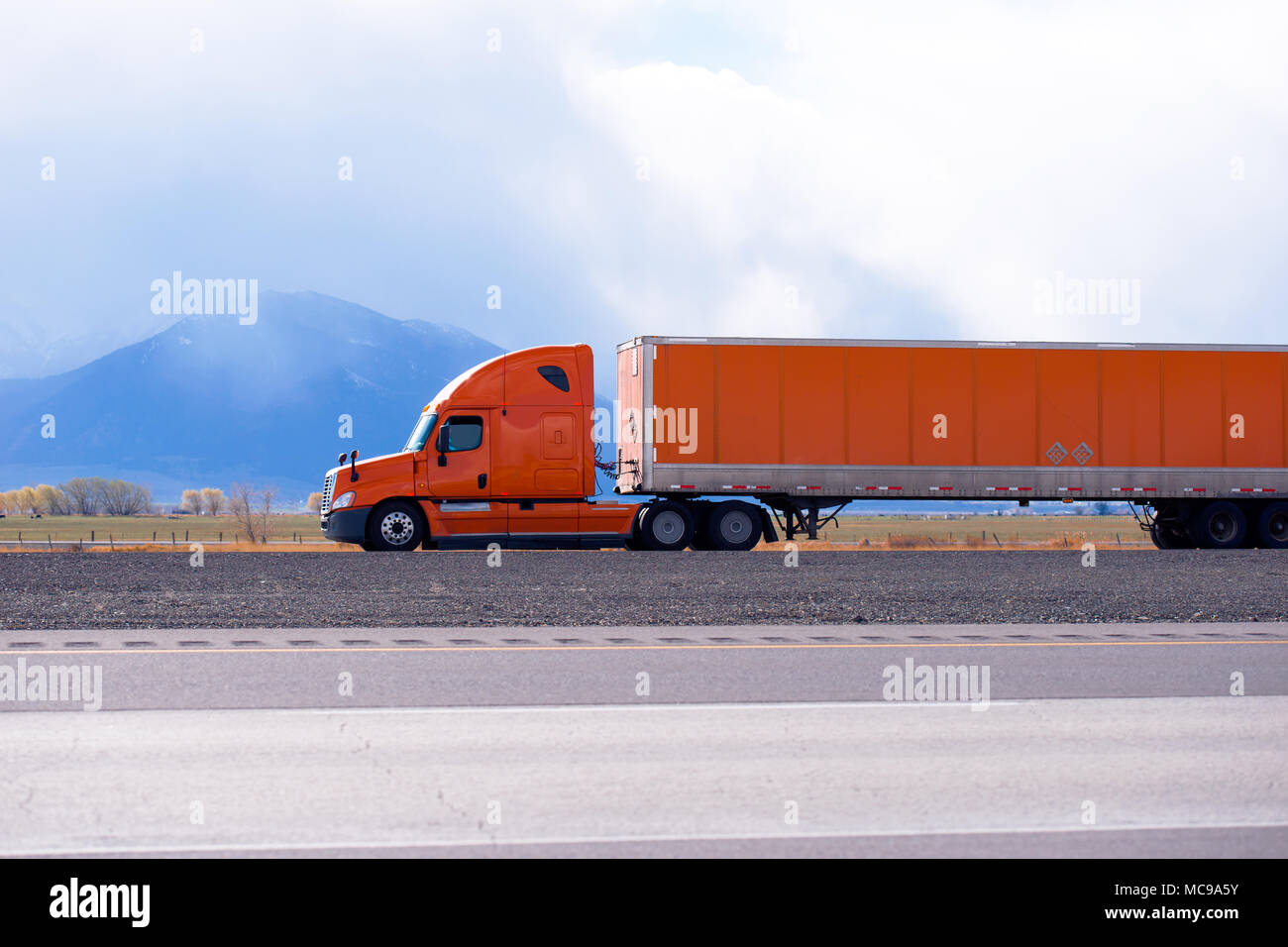 Profile of orange bonnet big rig pro semi truck with long dry van ...