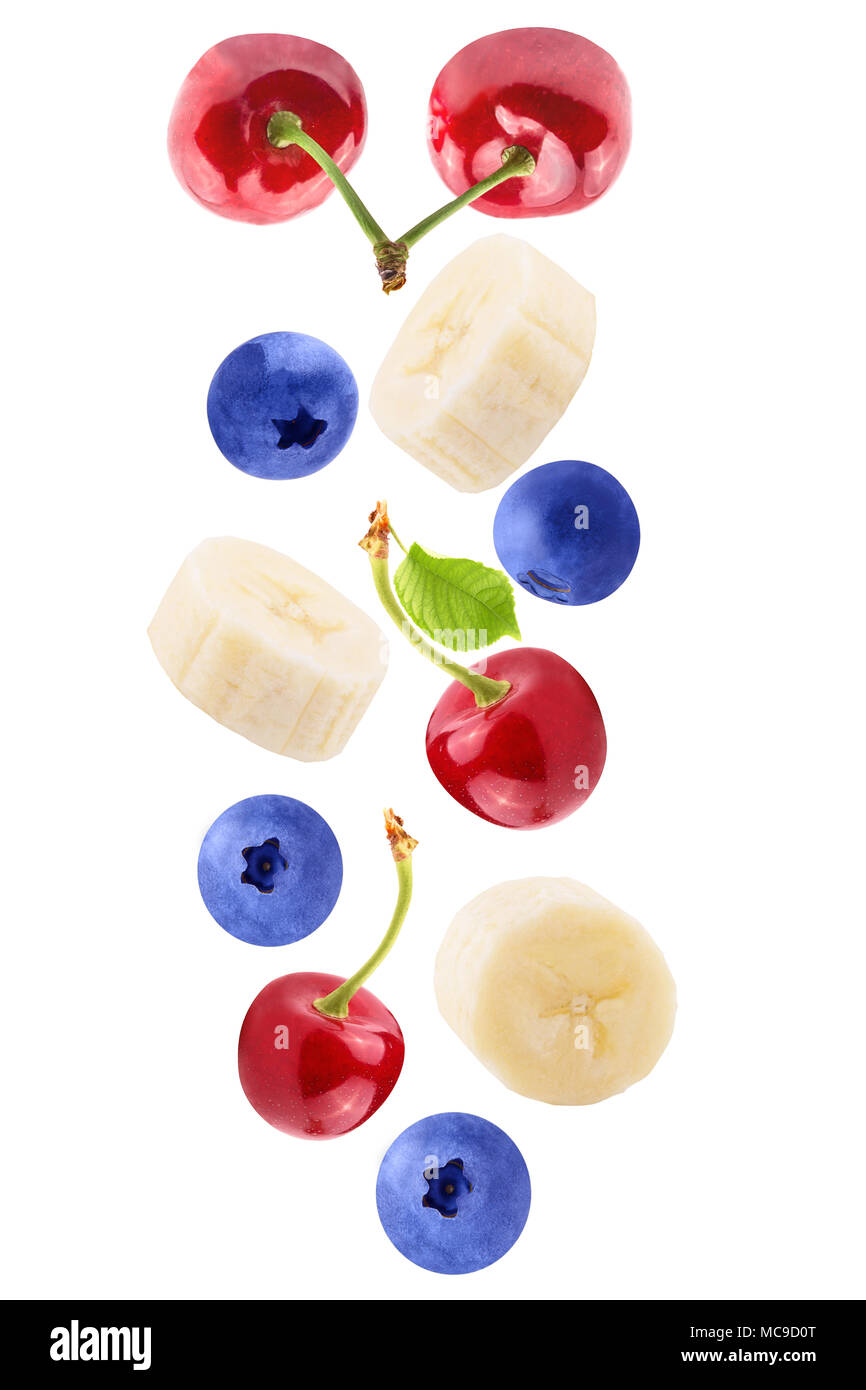 Isolated falling fruits. Falling sliced banana and berries fruits ...