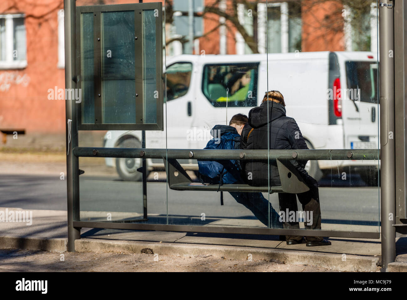 People waiting for the bus at the bus stop. View from the back Stock ...