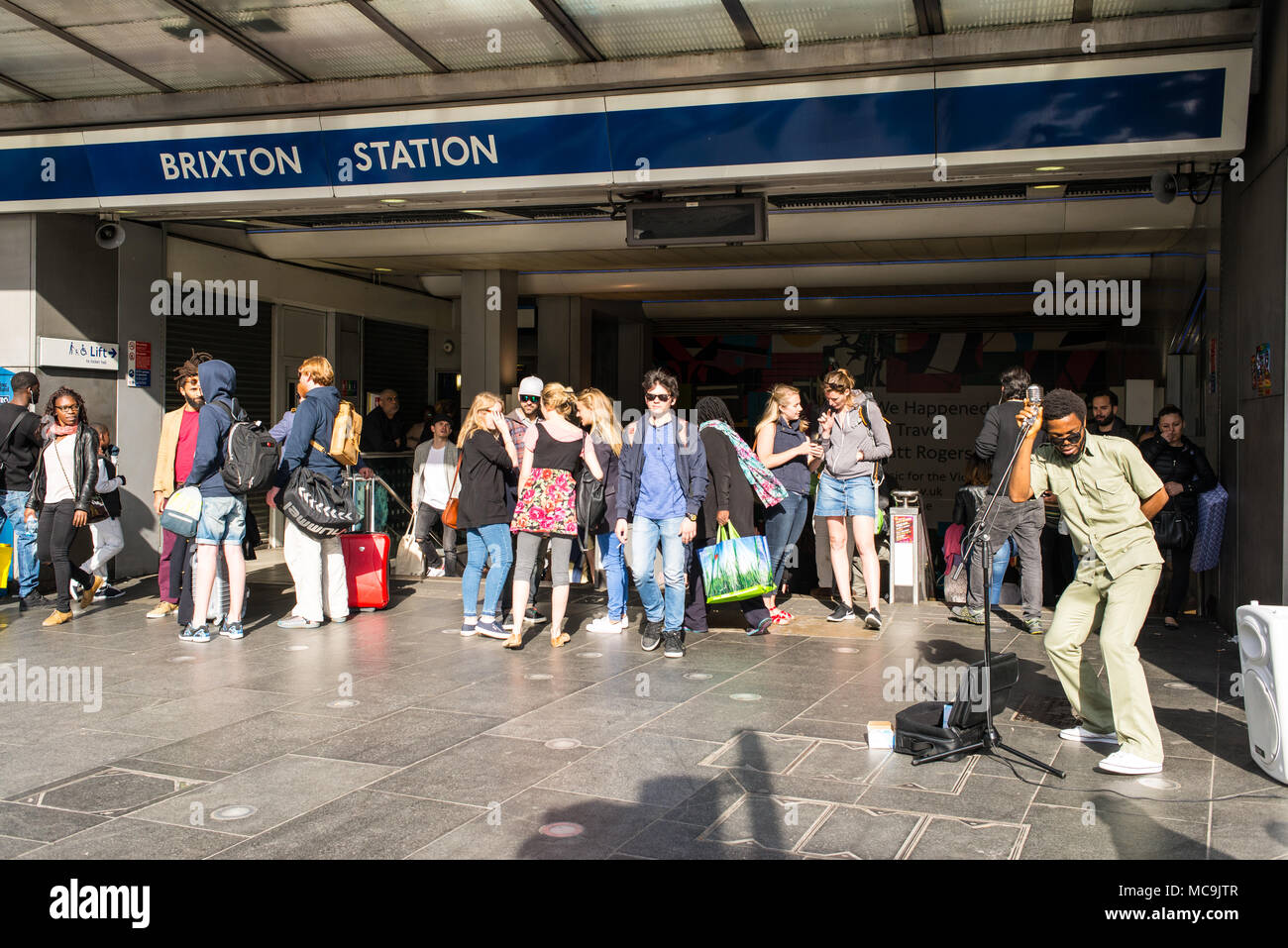 People walking and busker singer musician performing in front of the ...