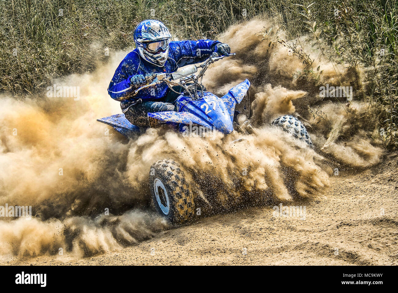 ATV rider creates a large cloud of dust and debris Stock Photo - Alamy