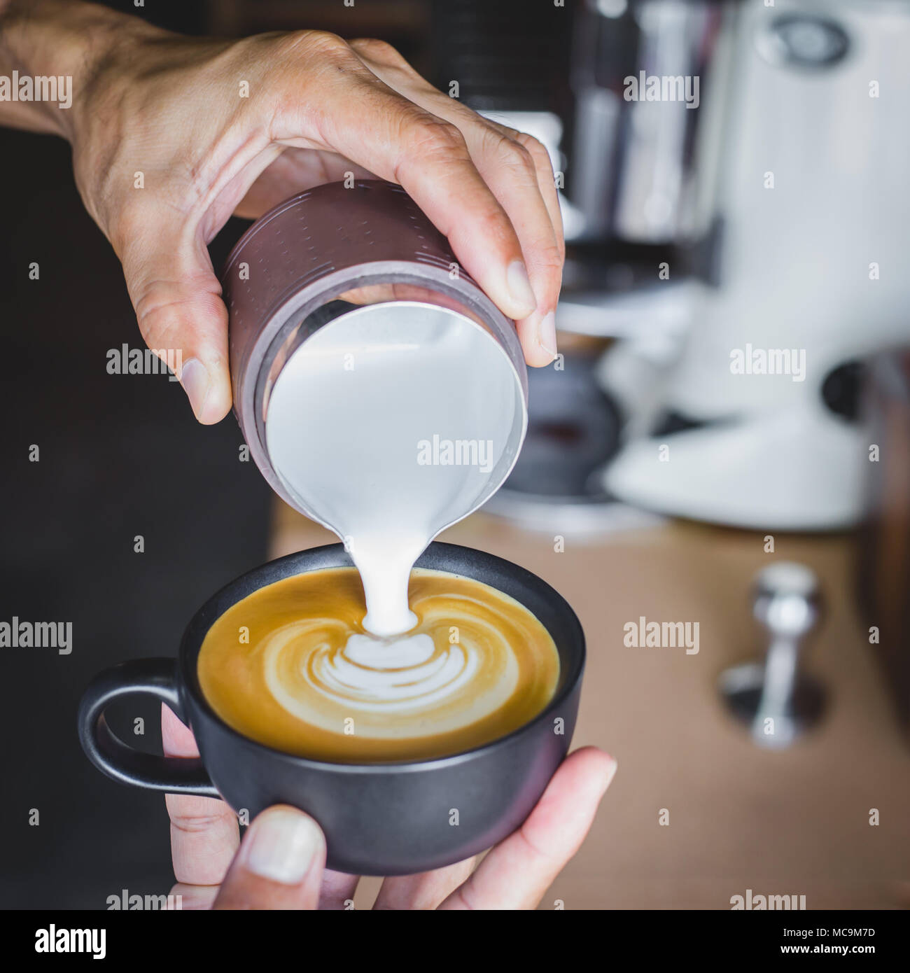 Barista making cafe latte art in coffee shop Stock Photo - Alamy
