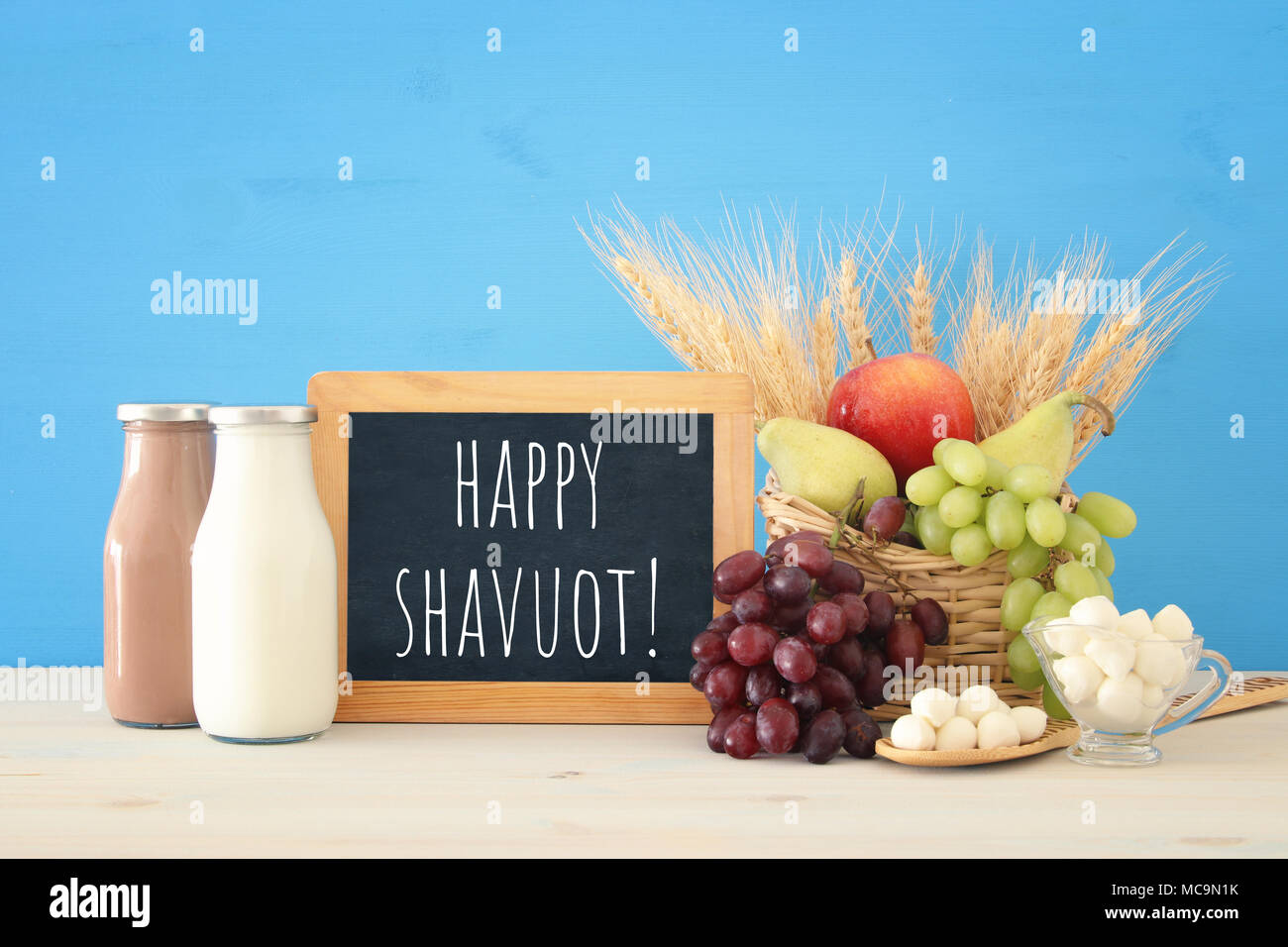 image of dairy products and fruits over wooden table. Symbols of jewish ...