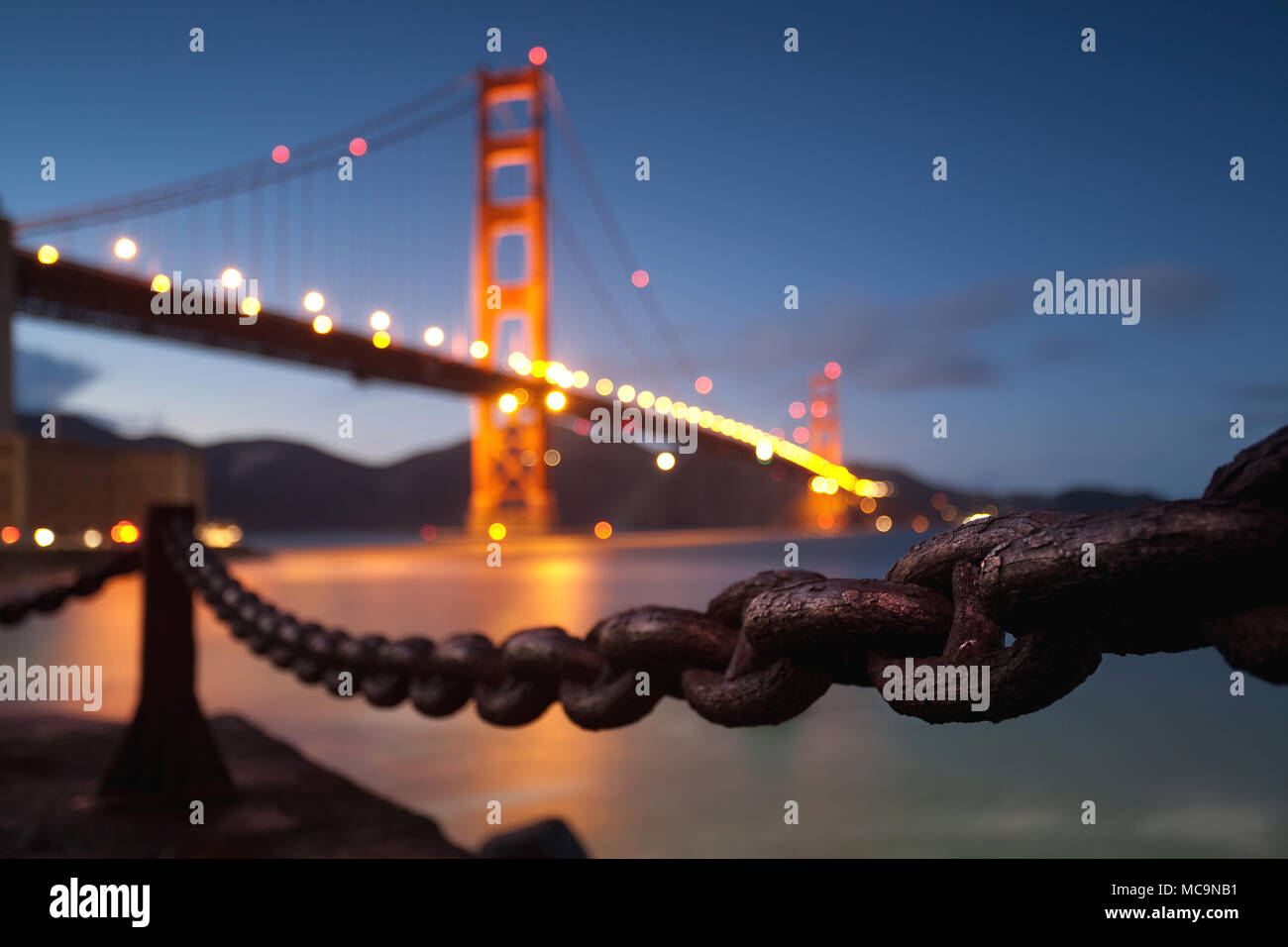 A suspenseful focus on the rust of a chain in front of the Golden Gate ...