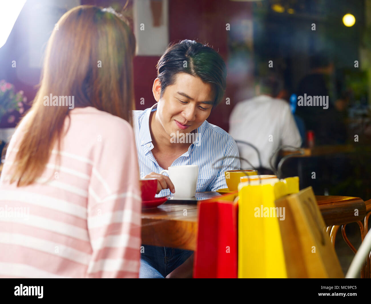 young asian couple relaxing chatting talking in coffee shop after ...