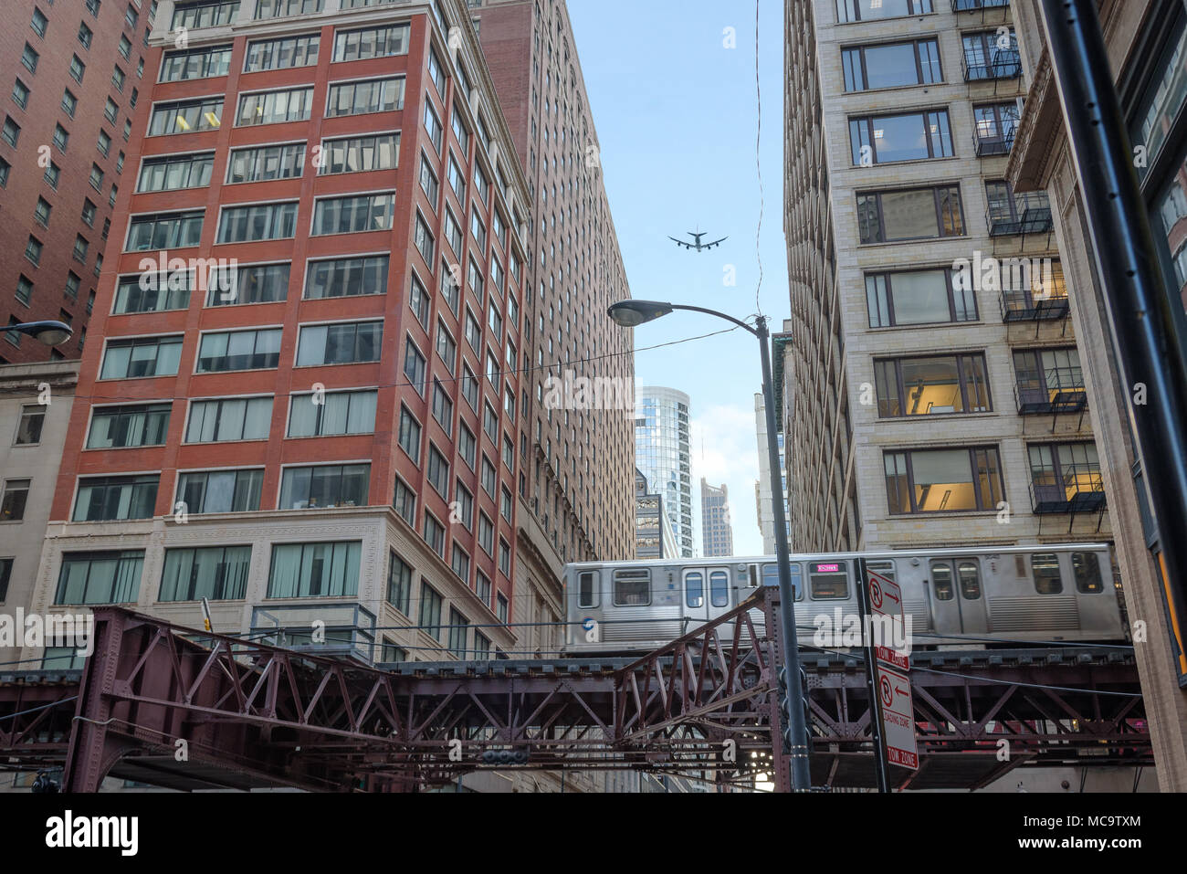 Train passing by in downtown Chicago and airplane flying overhead Stock ...