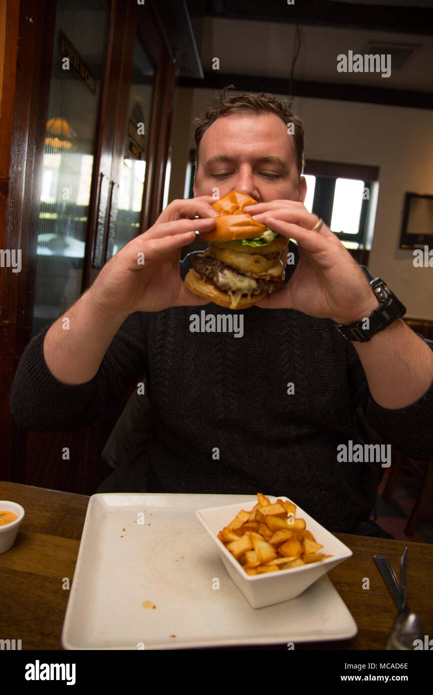 Man eating burger Stock Photo - Alamy