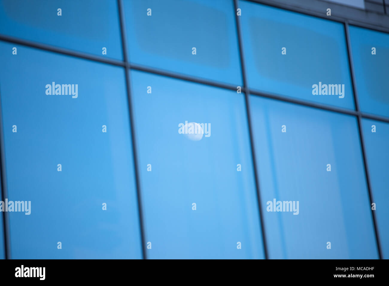 Moon reflected in office block windows Stock Photo - Alamy