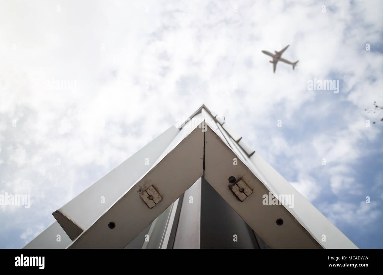 Corner of steel frame building against cloudy sky and airplane Stock ...