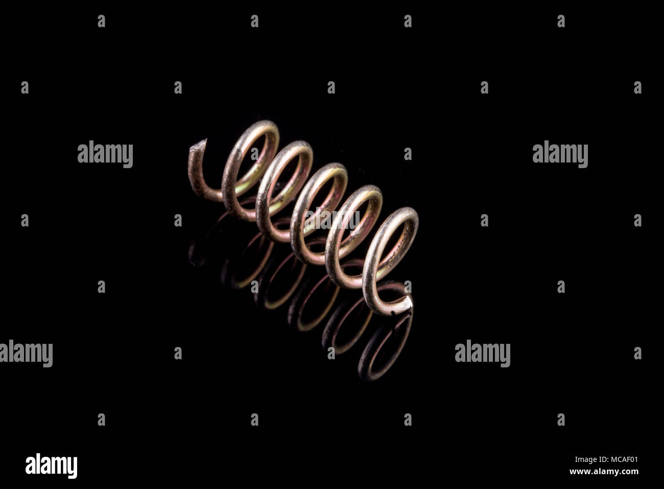 Metallic silver copper spring against black background Stock Photo - Alamy