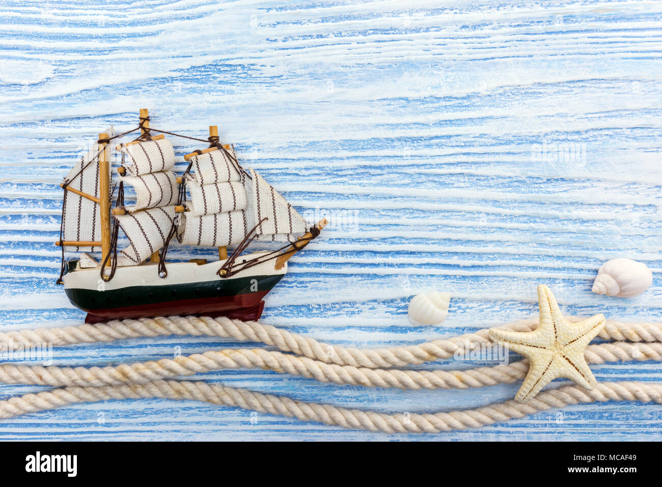 ship with shells and rope on blue wooden background. sea theme ...