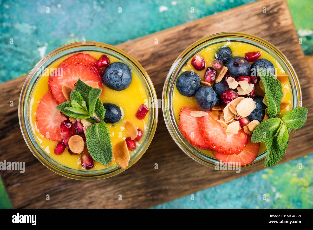 Mixed fresh fruits and mango pulp dessert in jar. Top close up view ...