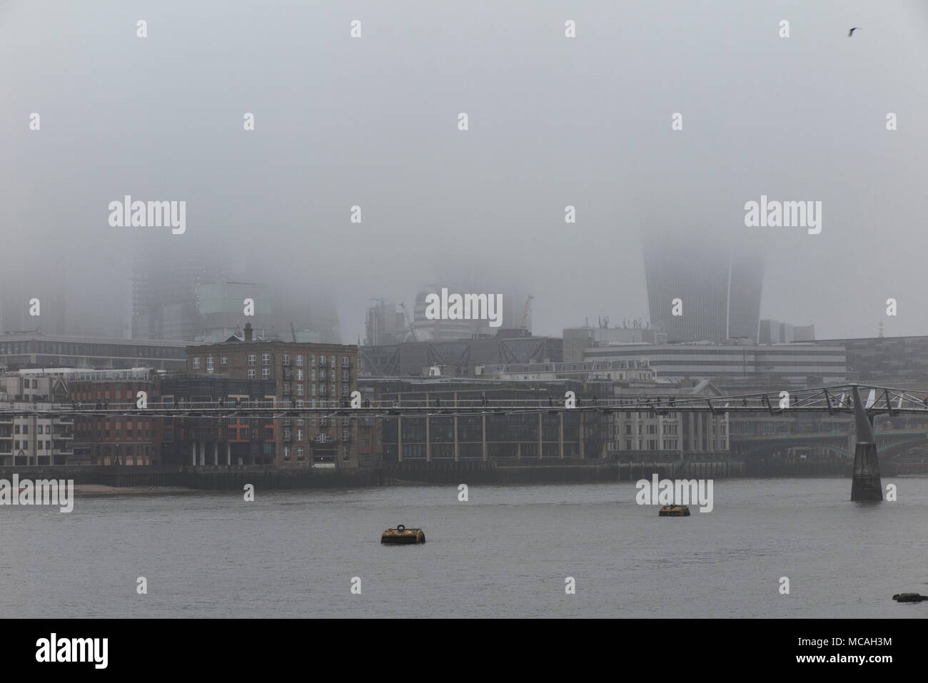 a gloomy, misty day in London with the skyscrapers shrouded in mist and ...