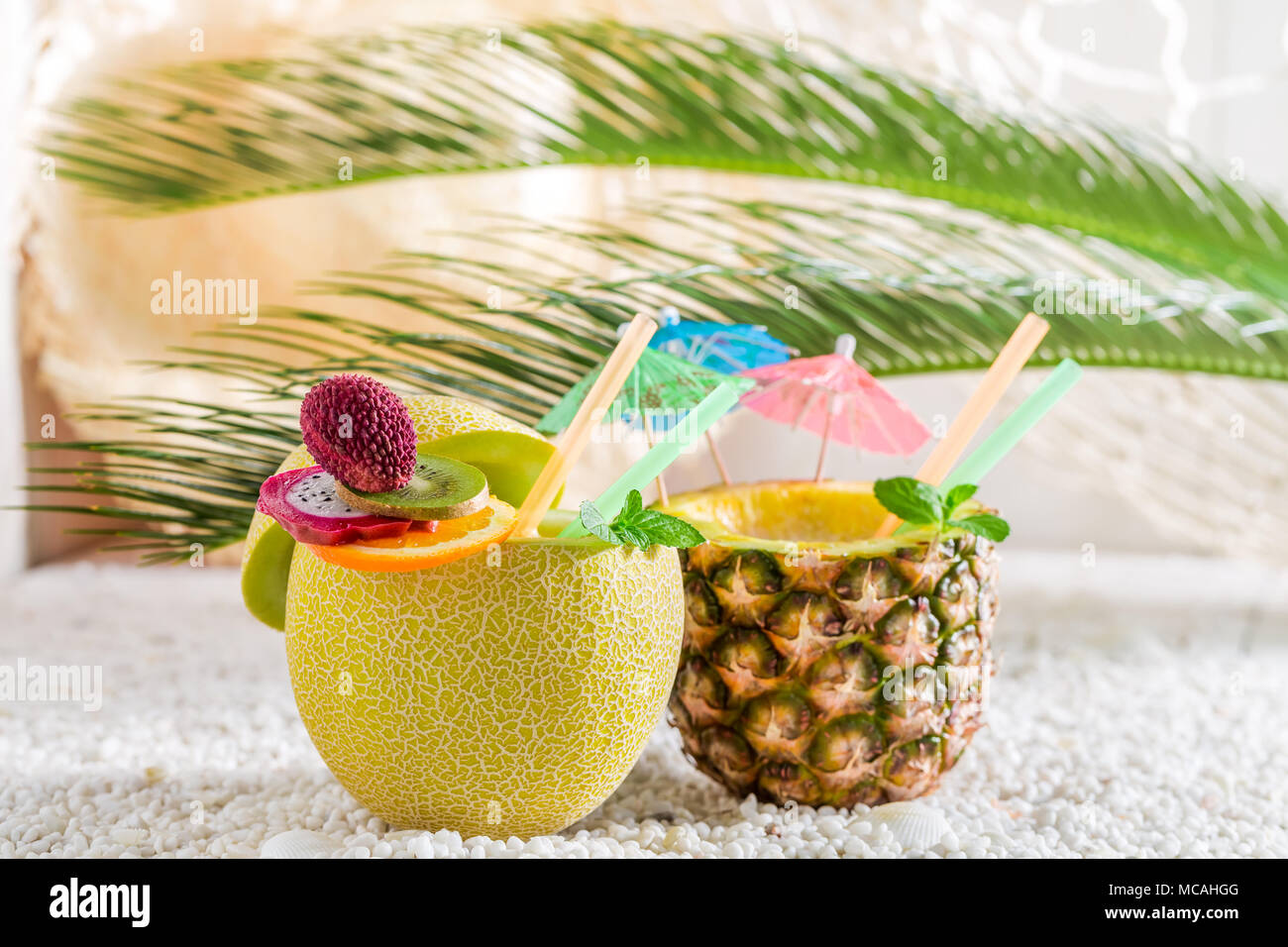 Tropical drinks in fresh fruits on white pebbles Stock Photo - Alamy
