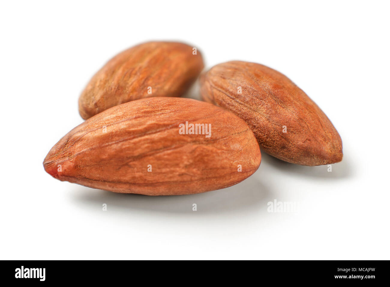 Three almond nut seeds, isolated on white background Stock Photo - Alamy