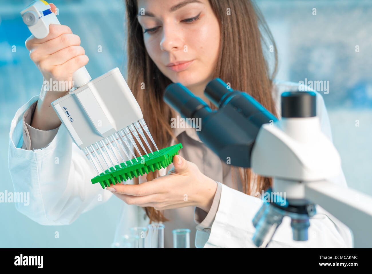 student woman with multi pipette and other PCR items in microbiological ...