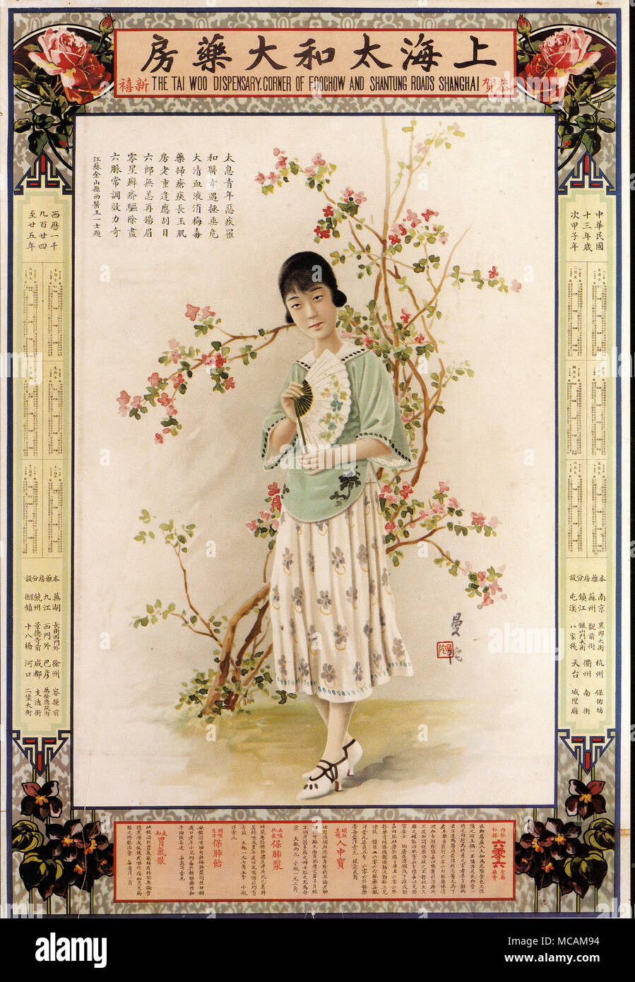 Woman stands in front of bush and holds opened fan Stock Photo - Alamy