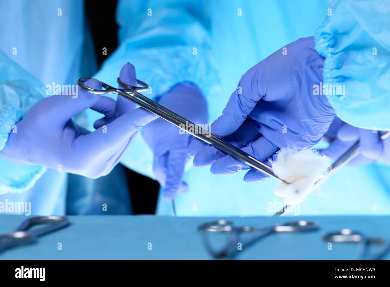 Surgeons hands holding surgical scissors and passing surgical equipment ...