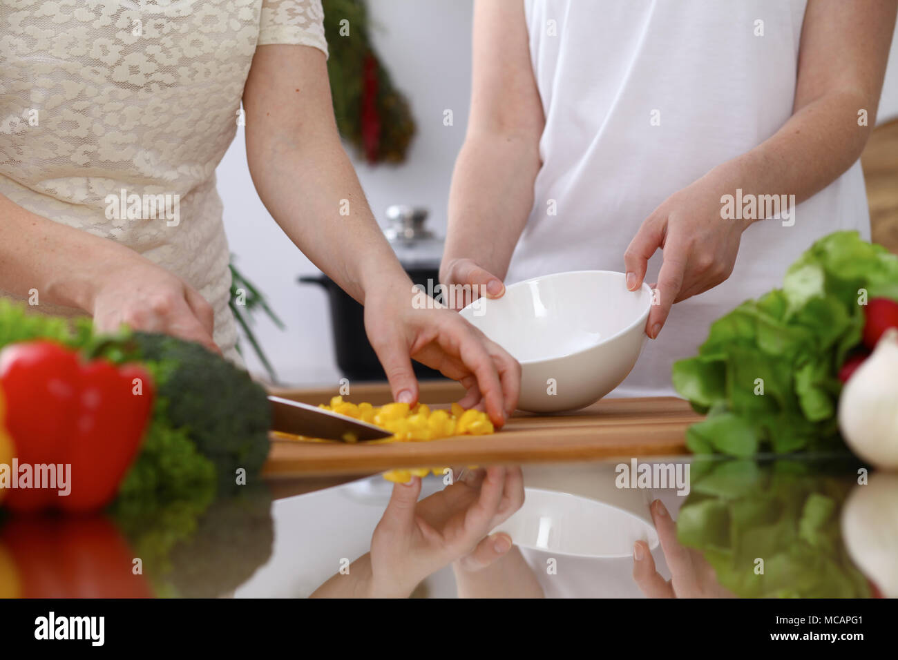 Closeup of human hands cooking in kitchen. Mother and daughter or two ...