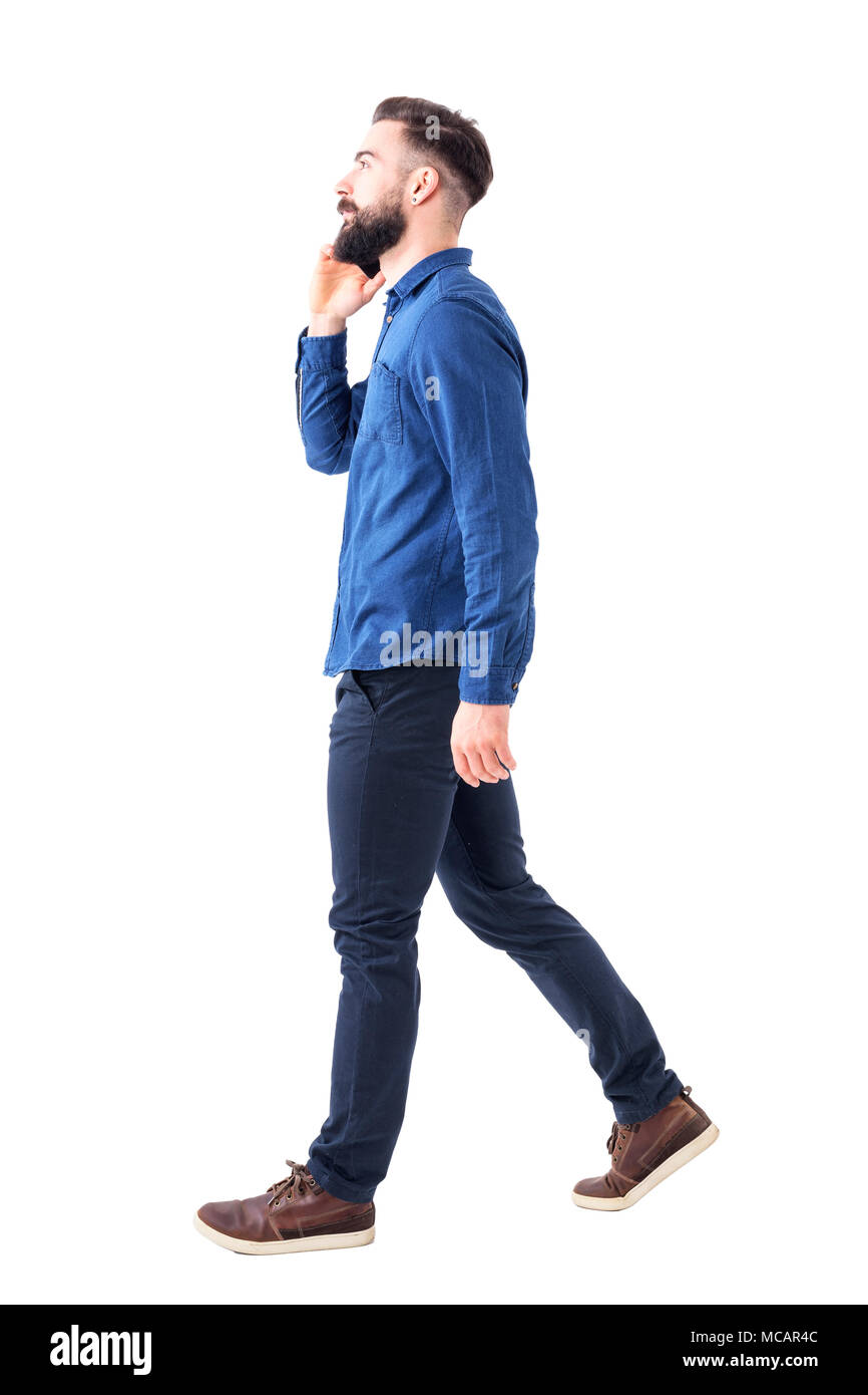 Side view of confident busy businessman talk on the phone walking and ...