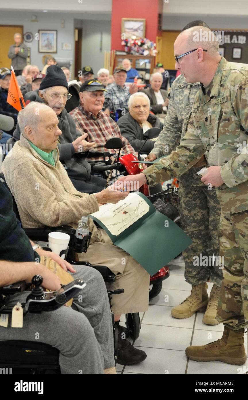 Navy Chief Warrant Officer (Ret.) Dale McElfresh receives a coin from ...