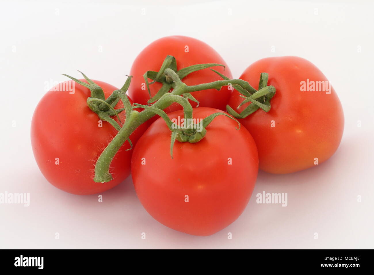 Four tomatoes on stem Stock Photo - Alamy