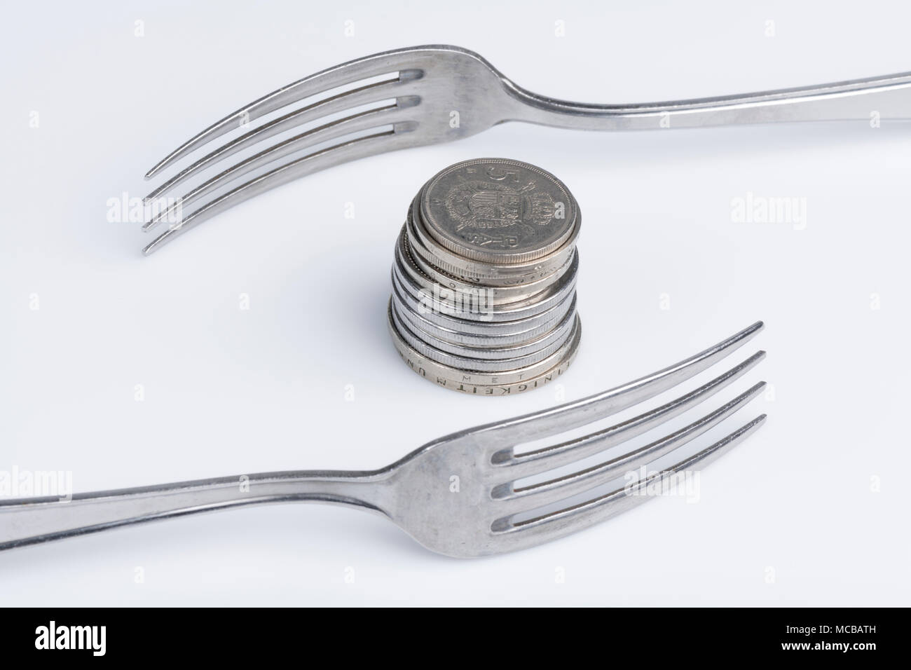 Conceptual representation of financial greed by two forks and coins ...