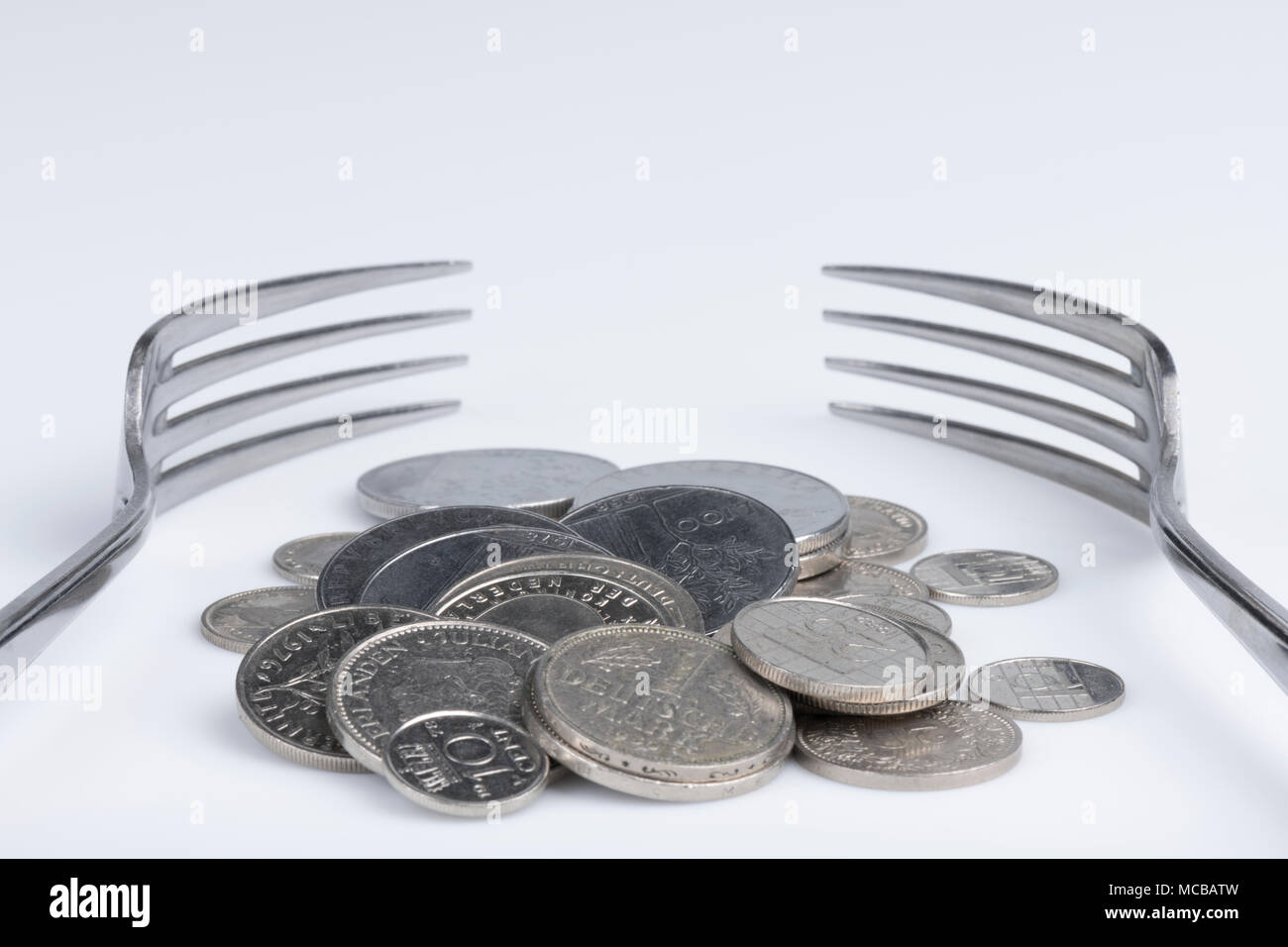 Conceptual representation of financial greed by two forks and coins ...