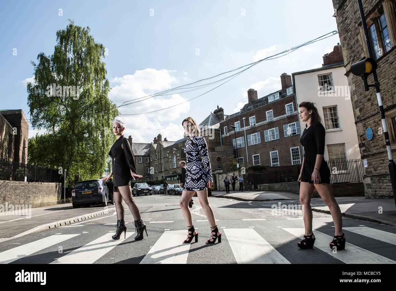 three ladies in heels cross zebra crossing Stock Photo - Alamy