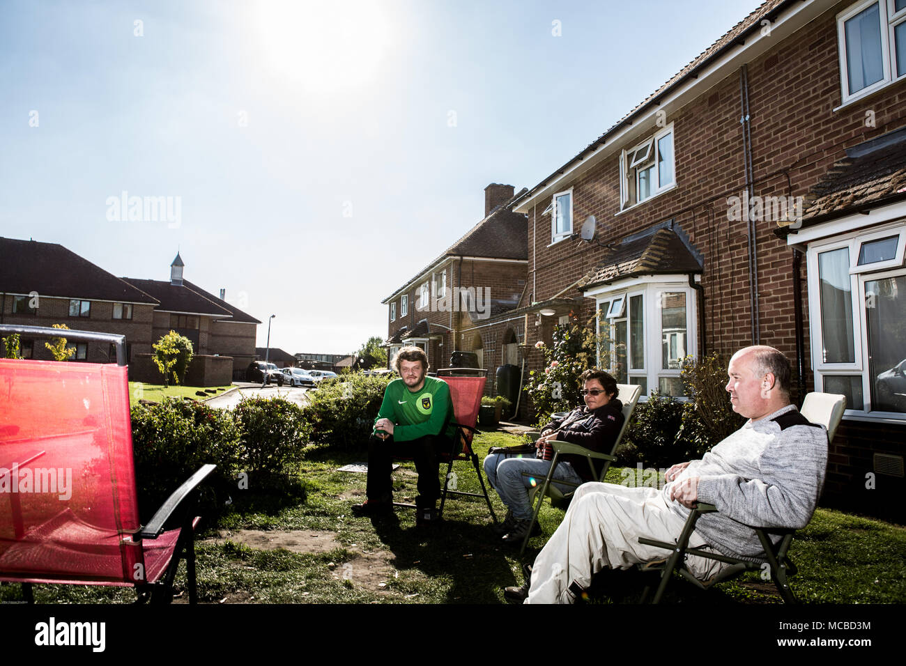 Group of residents sitting outside on social housing estate Stock Photo ...