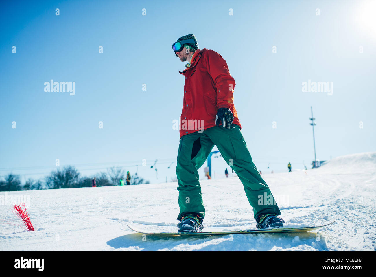 Snowboarder in glasses poses with board in hands Stock Photo - Alamy