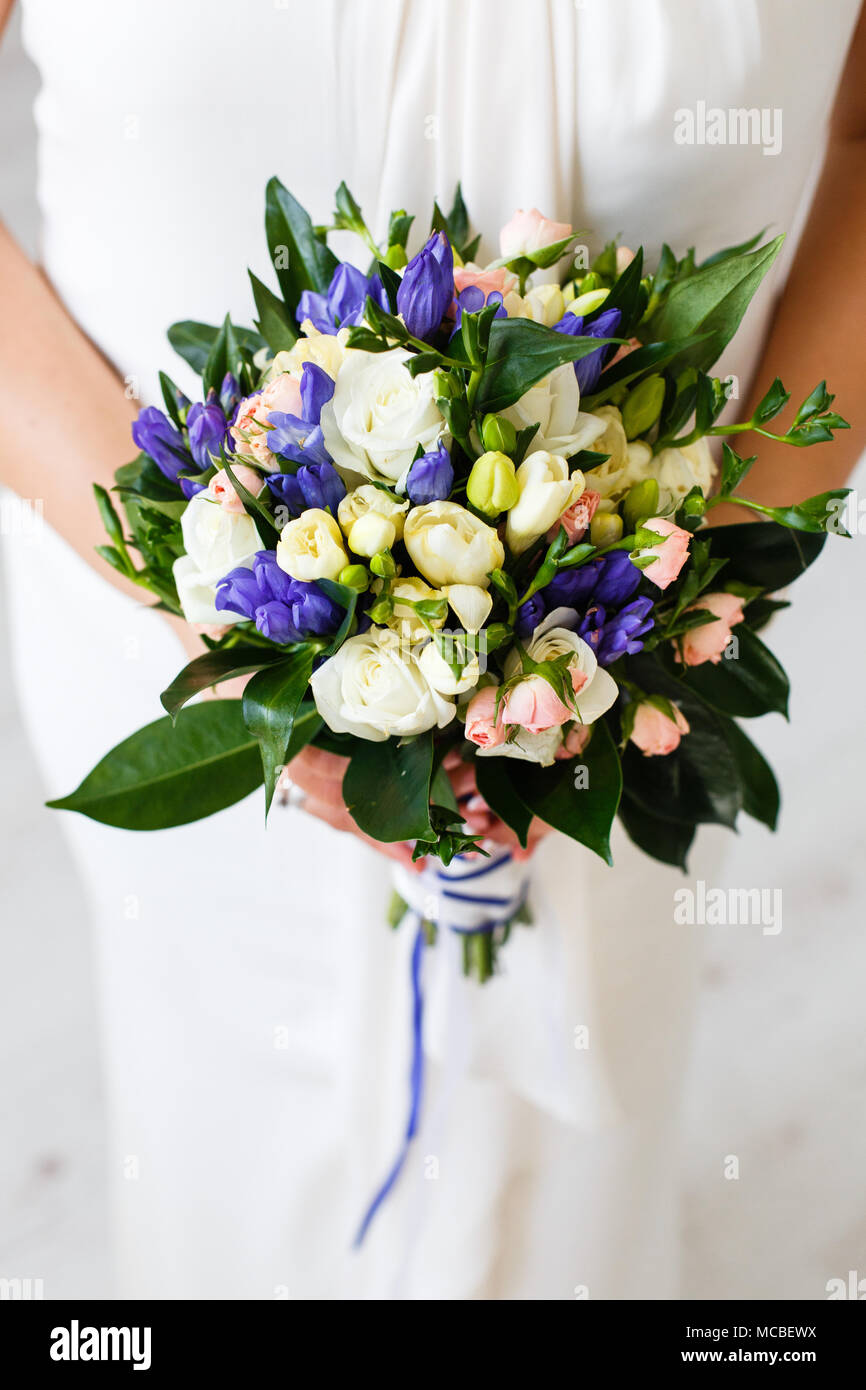 Wedding bouquet with roses, peonies and freesia in the hands of the ...