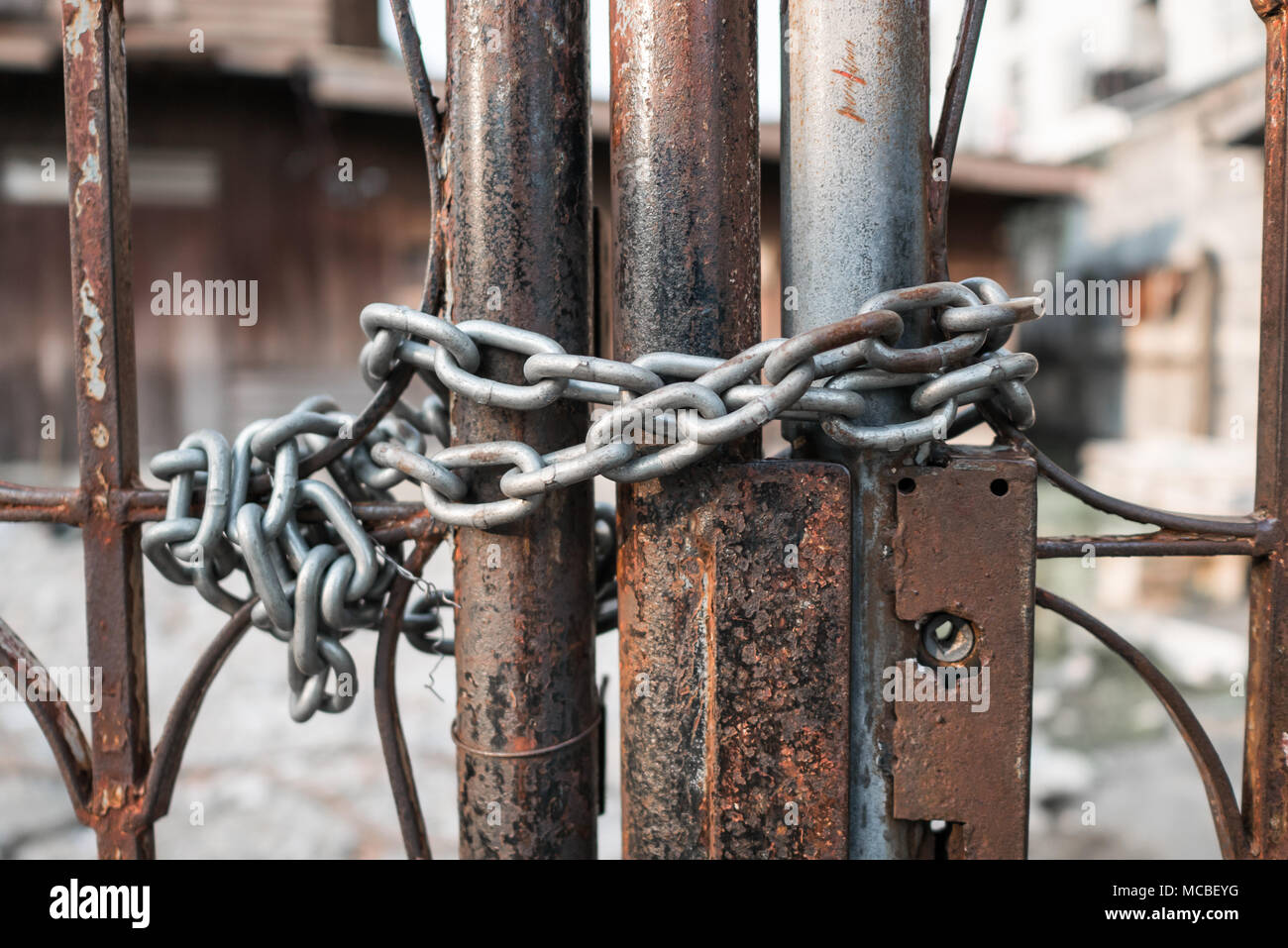 Rusty steel door locked with chain Stock Photo - Alamy