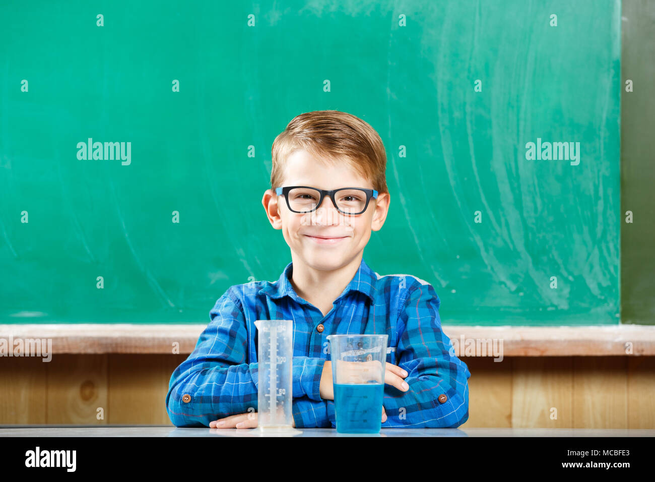 Cheerful school boy at the blackboard with measuring glasses Stock ...