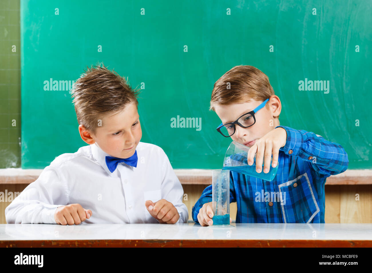 Two schoolboys learning capacity and measuring in school Stock Photo ...