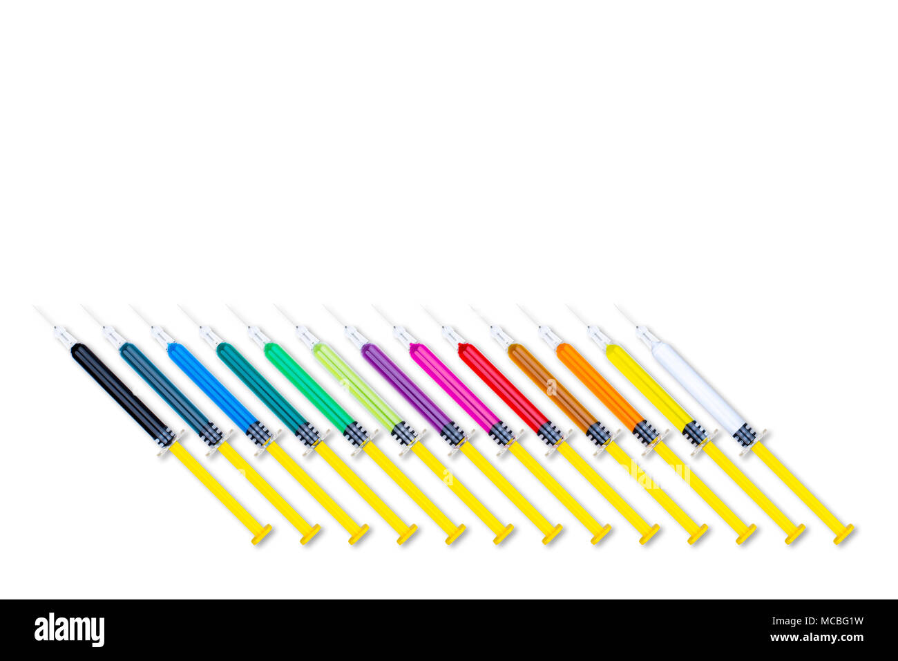 Multiple syringes with needles, filled with various colours of medicine ...