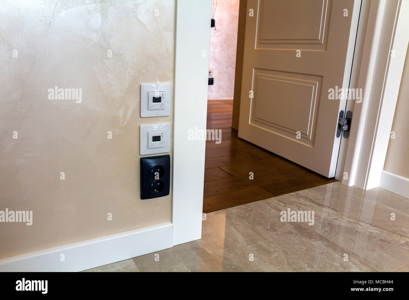 Modern house interior with warm floor controller panels on the wall ...