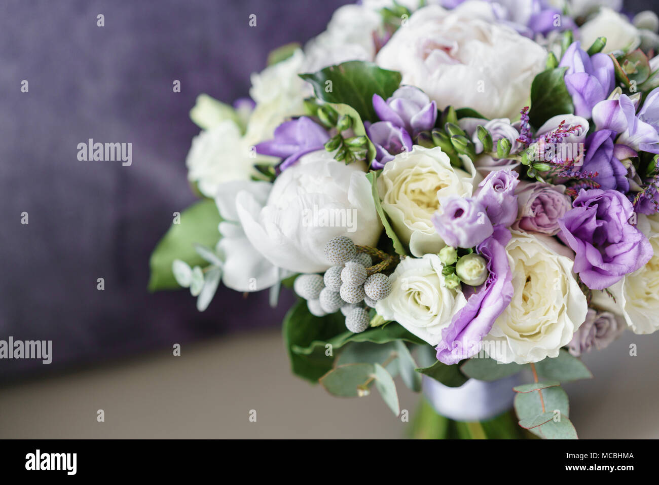 Brides wedding bouquet with peonies, freesia and other flowers on black ...