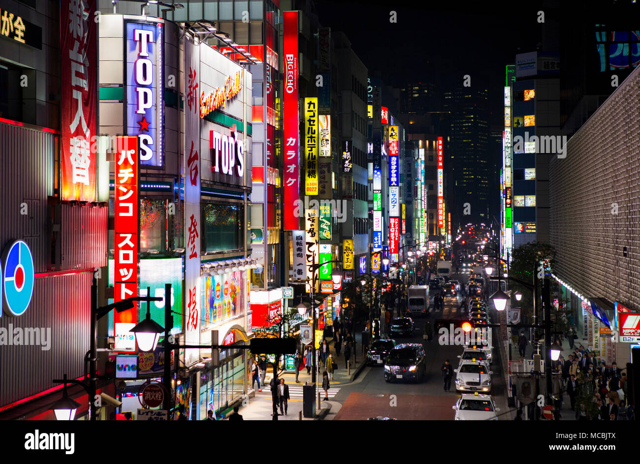 View into a street with illuminated advertising, shops, restaurants and ...