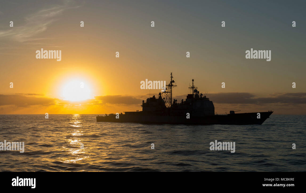 The sun rises over the Ticonderoga-class guided-missile cruiser USS Hue ...