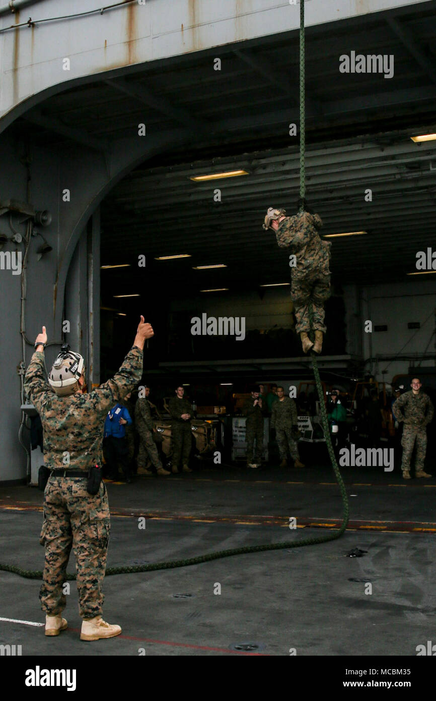 A Marine with the 31st Marine Expeditionary Unit fast ropes from the ...