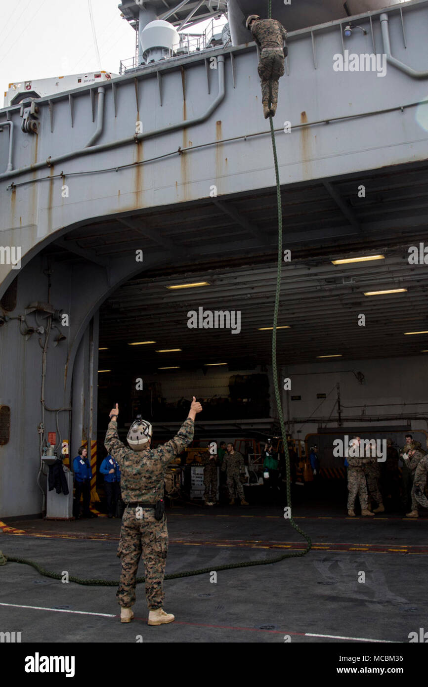 A Marine with the 31st Marine Expeditionary Unit fast ropes from the ...