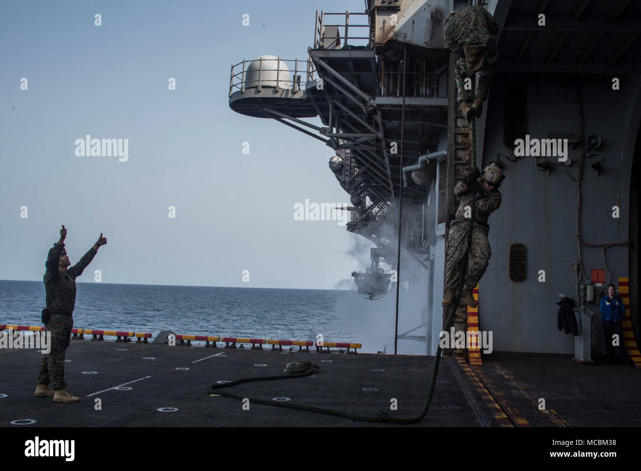 Marines with the 31st Marine Expeditionary Unit fast rope from the exit ...