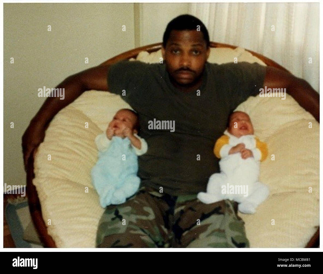 Herman Adams sits with his sons, Julien and Daniel, in their home in ...