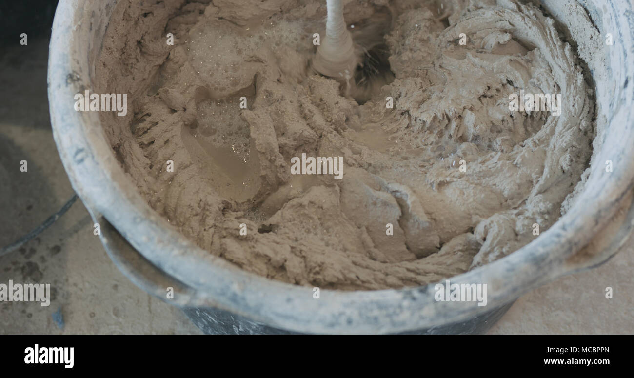 mixing concrete plaster with electric mixer, wide photo Stock Photo - Alamy