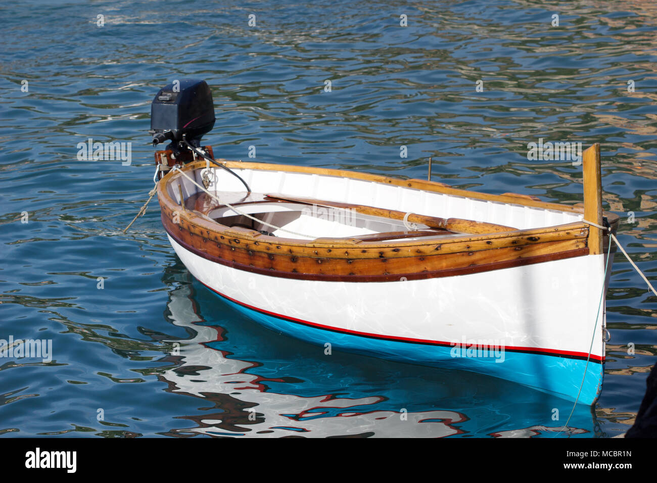 Docked boat along coastline beach at sunset. Small boat on water Stock ...