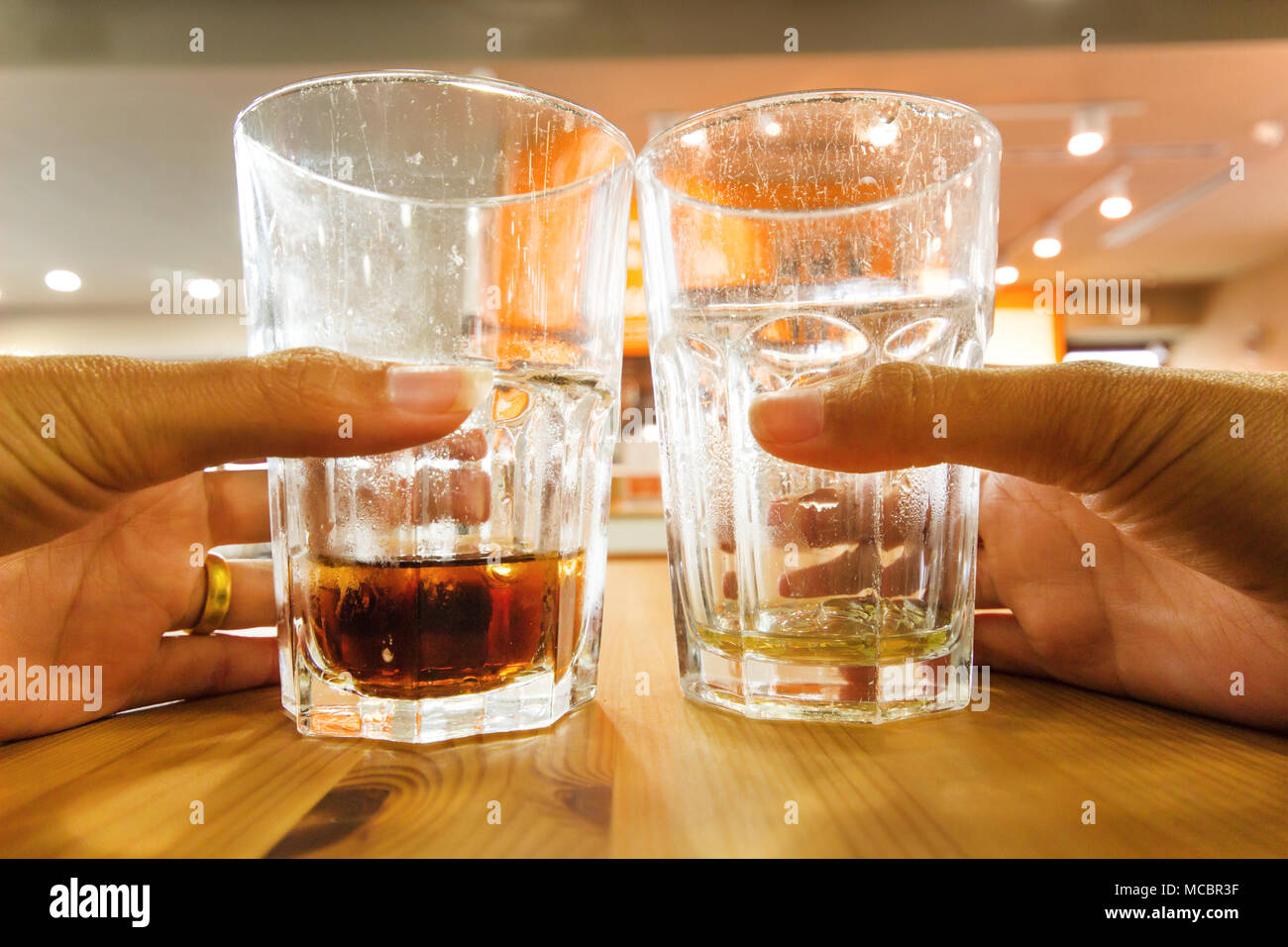 Hand holding a glass of water on the table background Stock Photo - Alamy