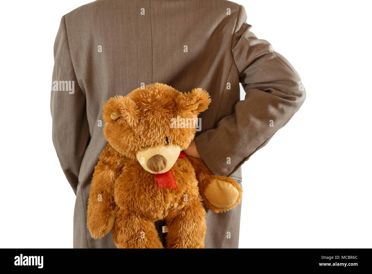 Businessman holding teddy bear in his behind in white background ...