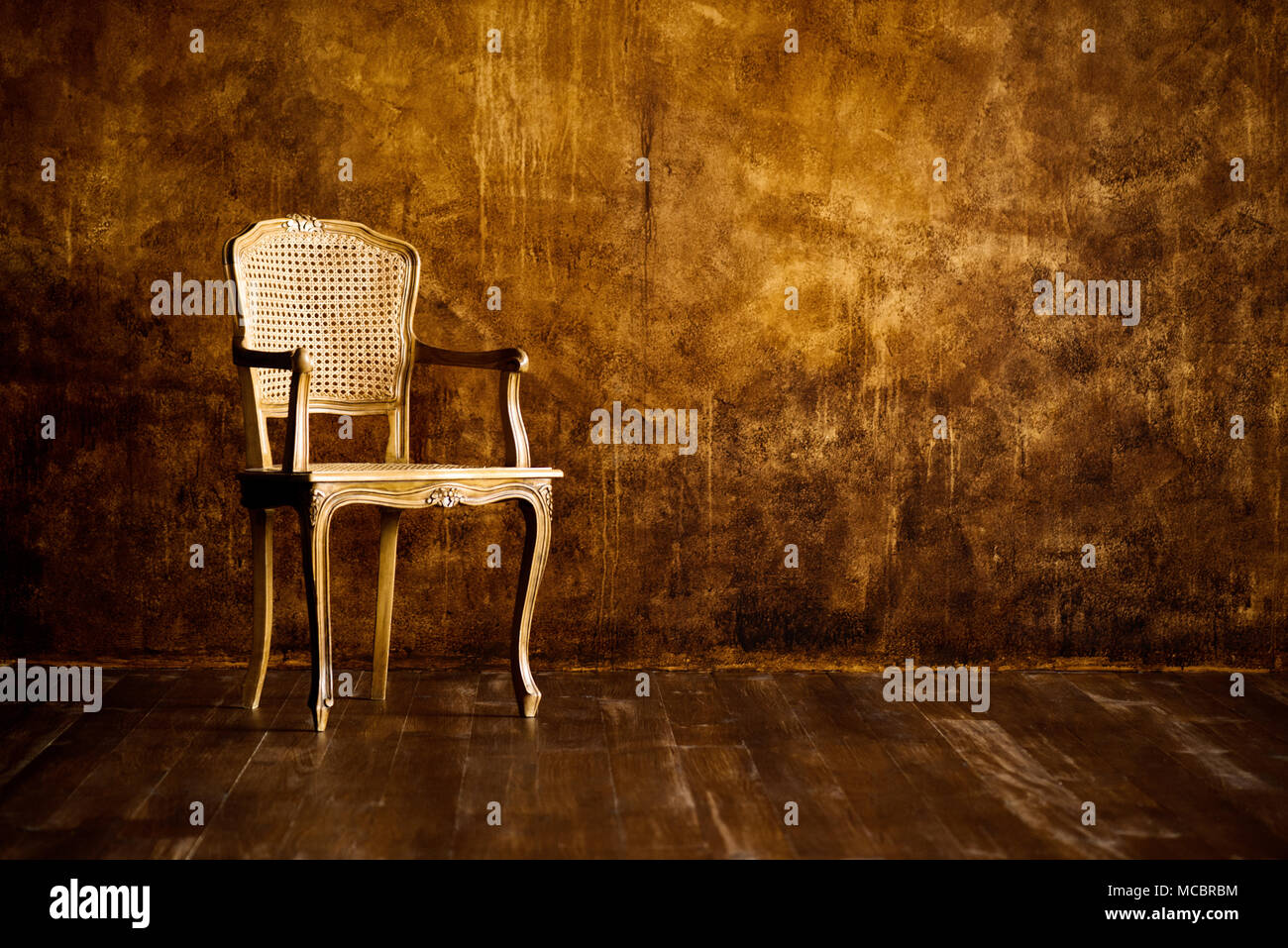 old chair on a brown wall background Stock Photo - Alamy